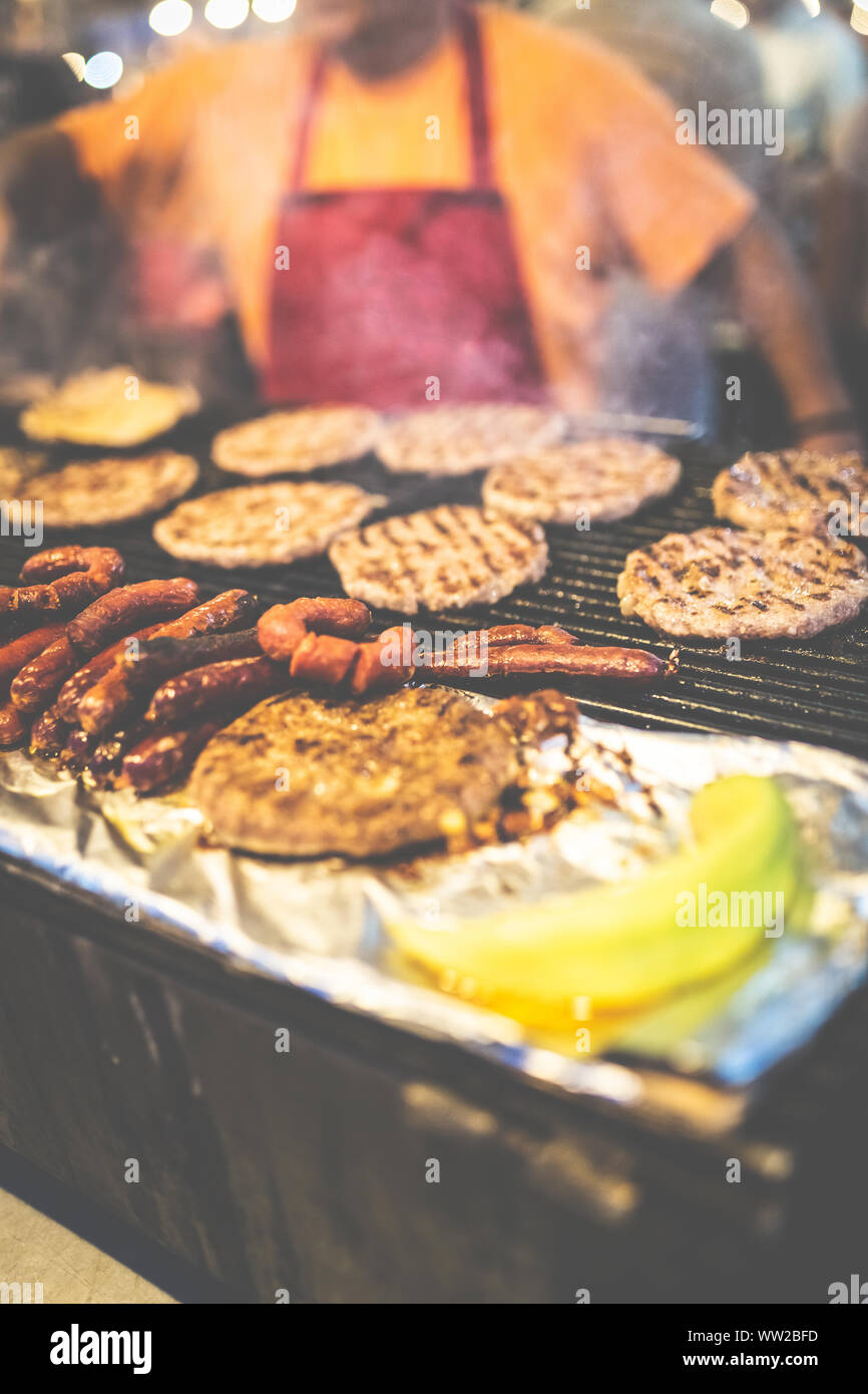 Street food barbecue burgers and sausages preparation. Fast food ...