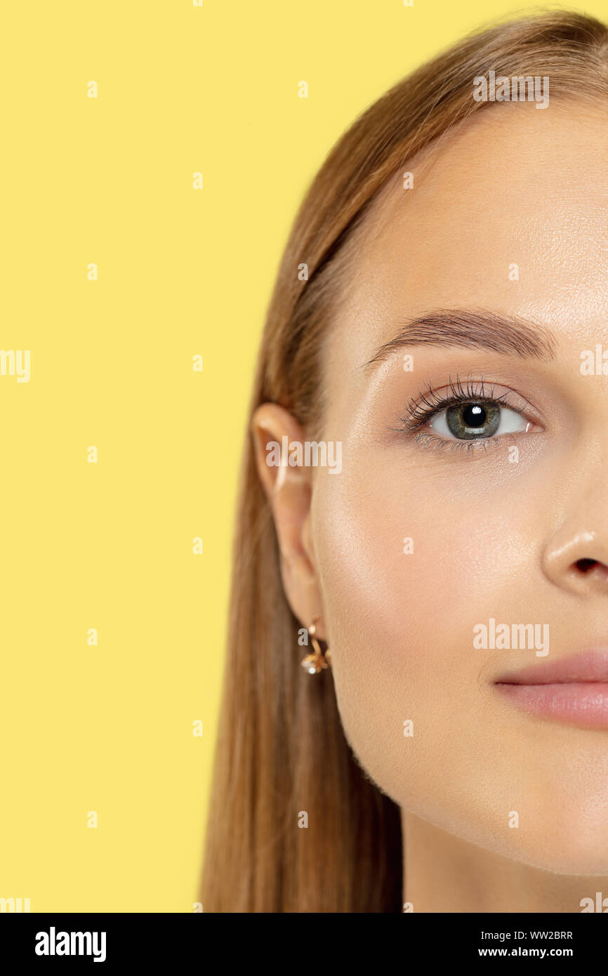 Caucasian young woman's close up shot on yellow studio background ...