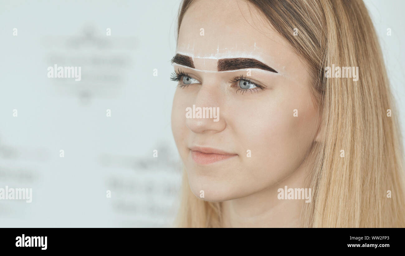 Create permanent eyebrow makeup. Marking the shape of the eyebrows ...