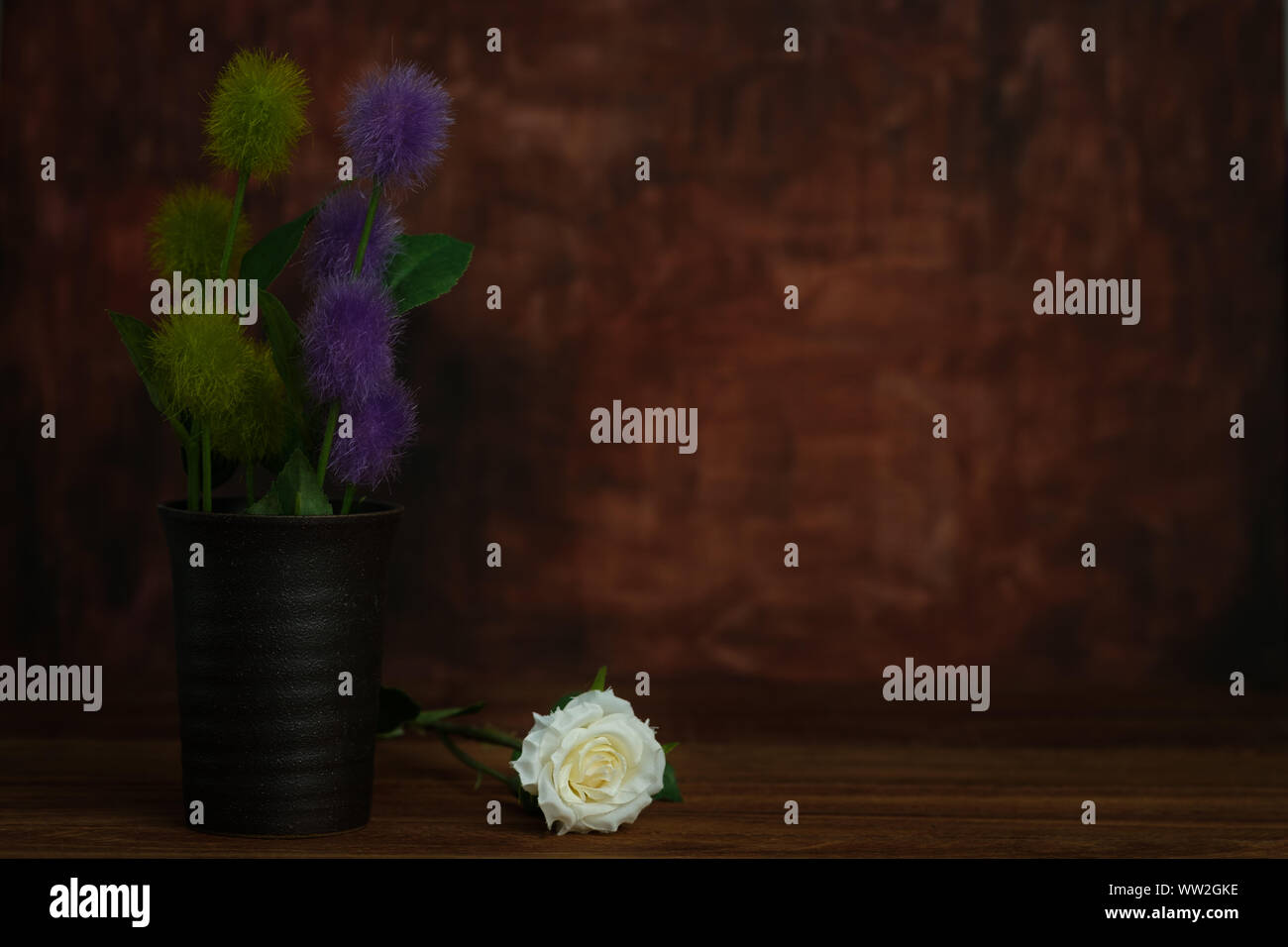 Still life with flower in the pottery vase on rustic wooden table ...