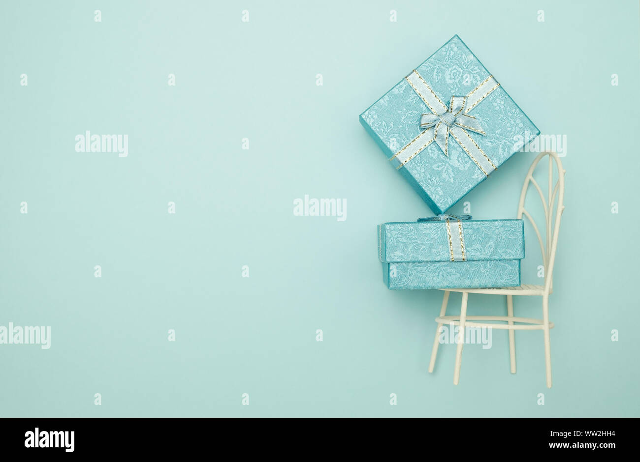 Gift box and iron chair on blue background with copy space for write ...