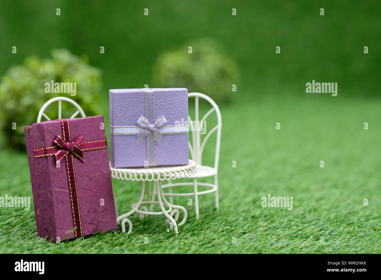 Gift box on white field chair in green garden, with copy space to write ...