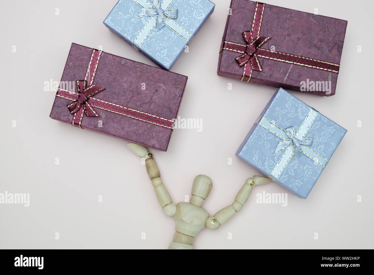 Wooden dummy carrying a wooden box on pink background with copy space ...