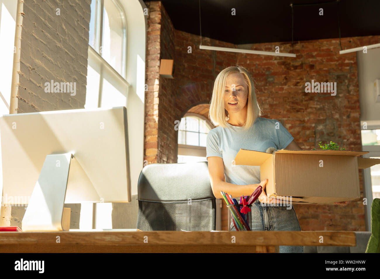 A young businesswoman moving in the office, getting new work place ...