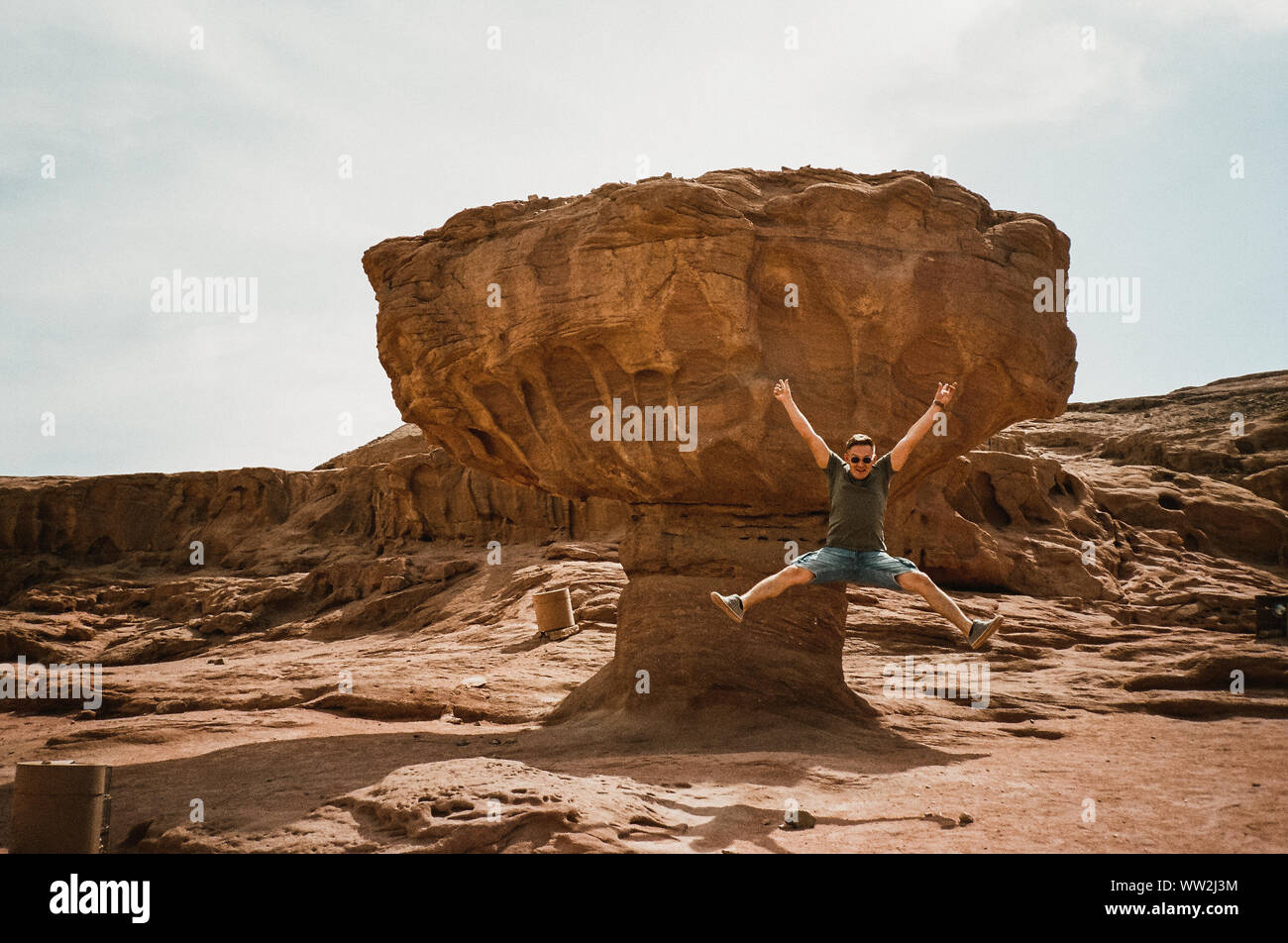 Man jumping in front of rock in Jordan Stock Photo - Alamy
