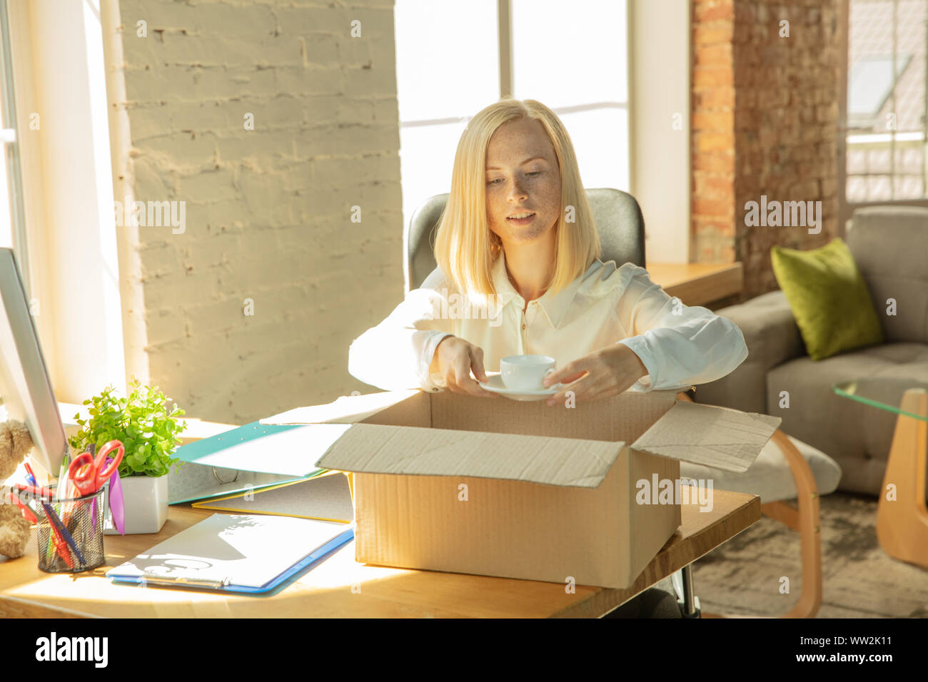 A young businesswoman moving in the office, getting new work place ...
