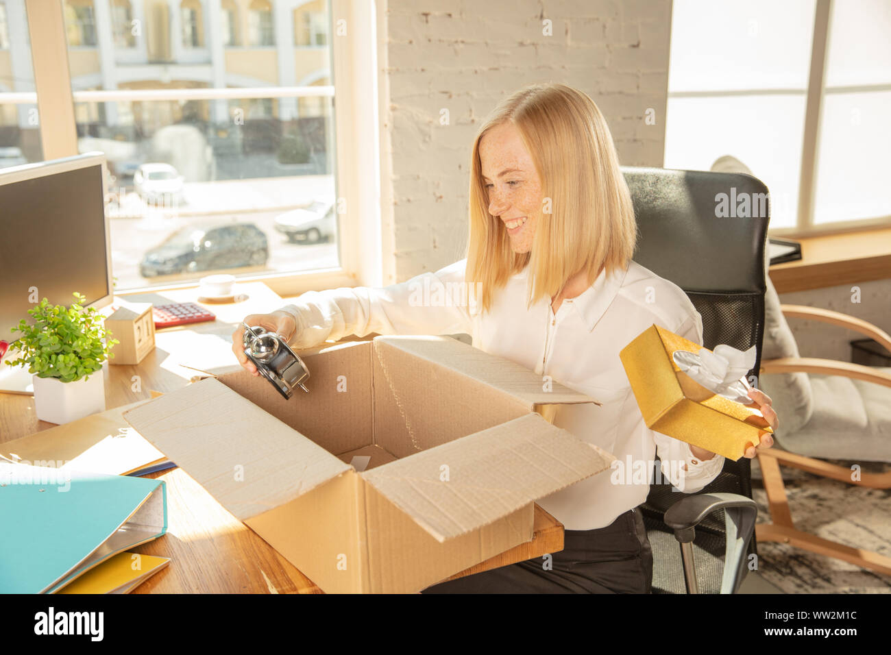 A young businesswoman moving in the office, getting new work place ...