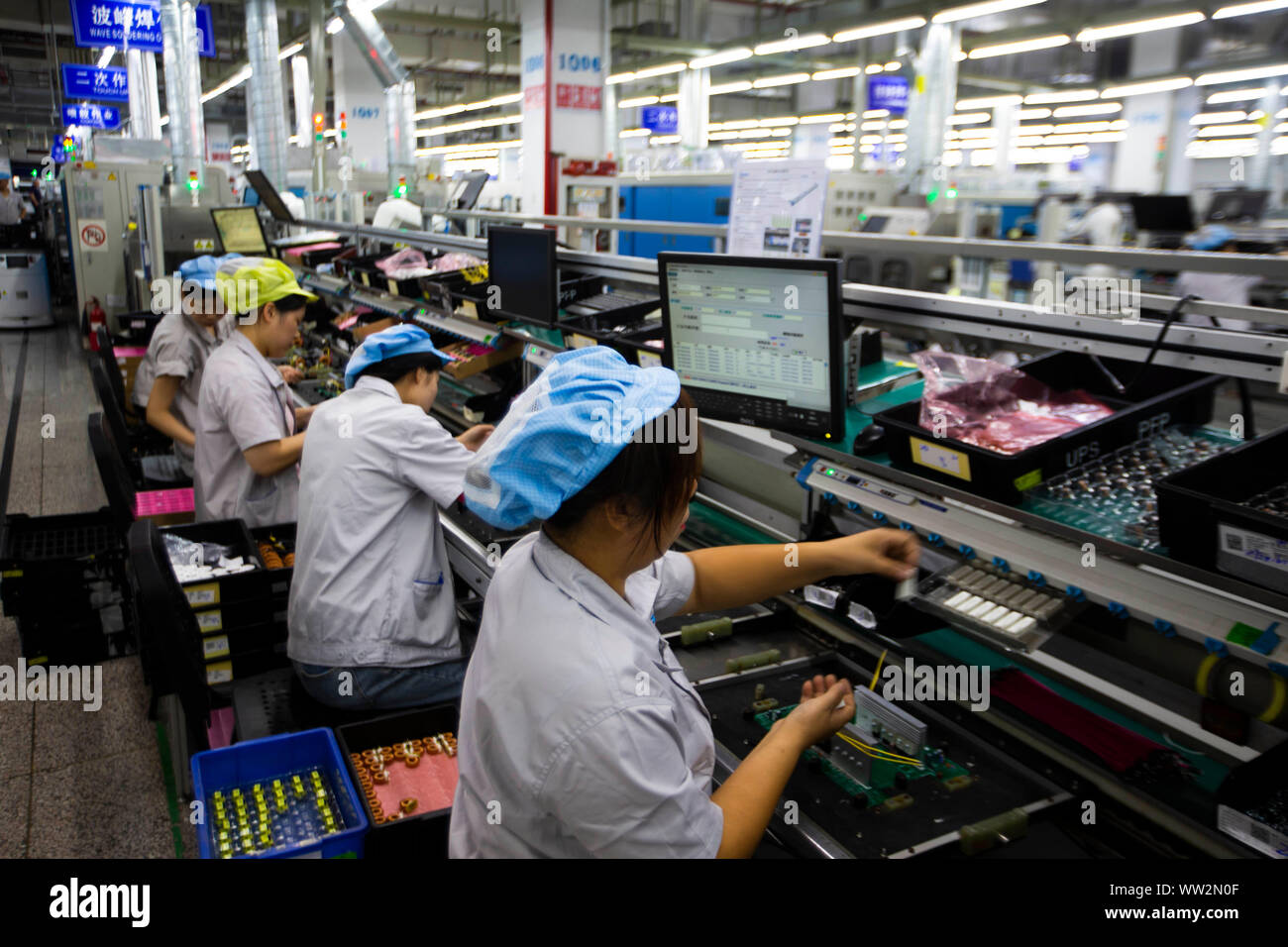 Chinese workers assemble batteries for electric vehicles at the plant ...