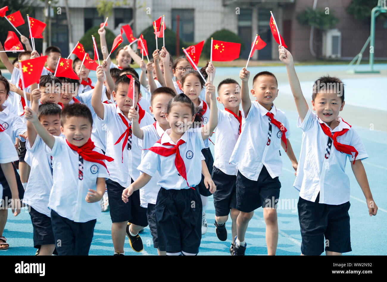 Young Chinese students wave Chinese national flags during a celebration ...