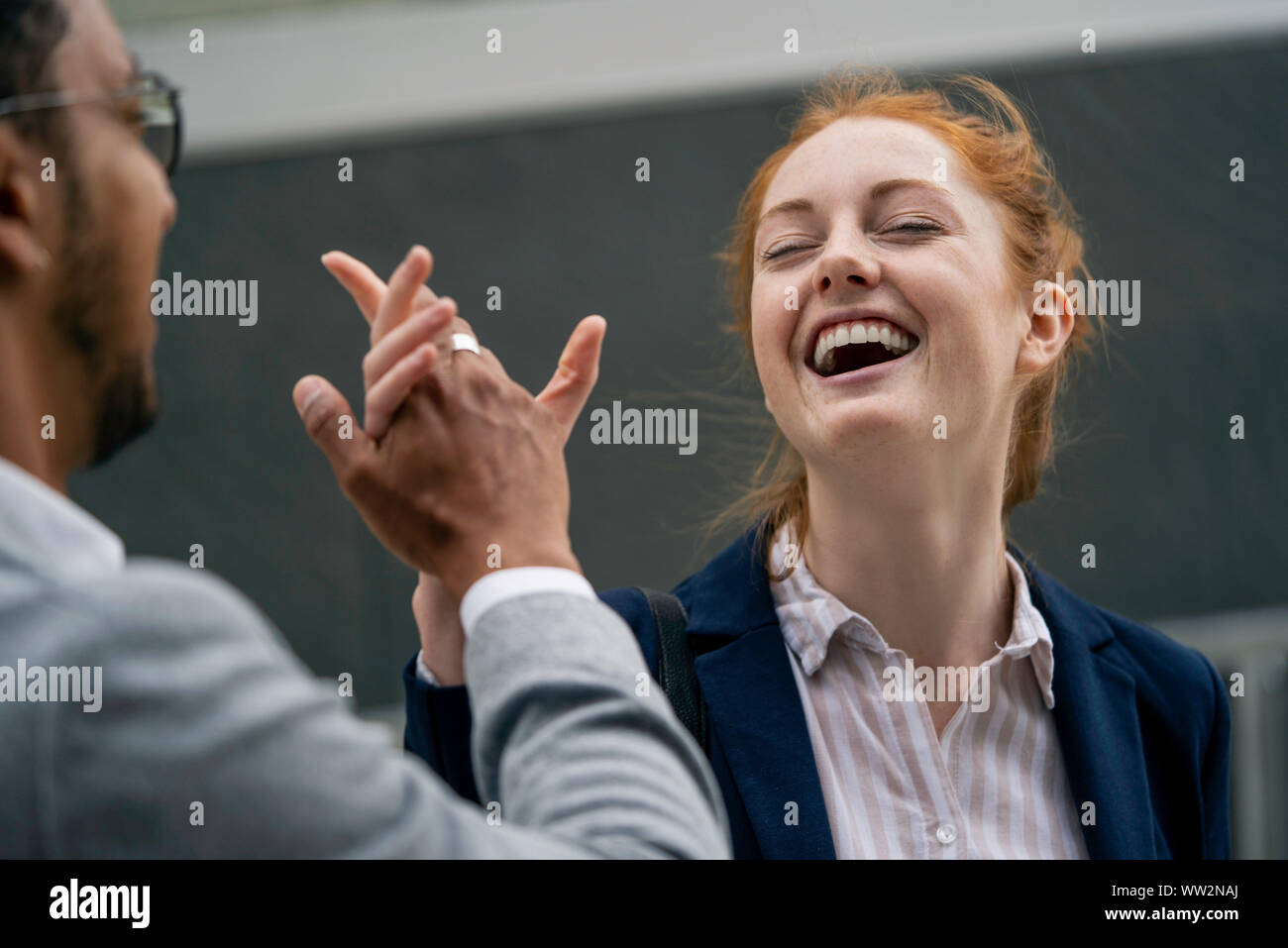 Couple giving-high five outdoors Stock Photo - Alamy