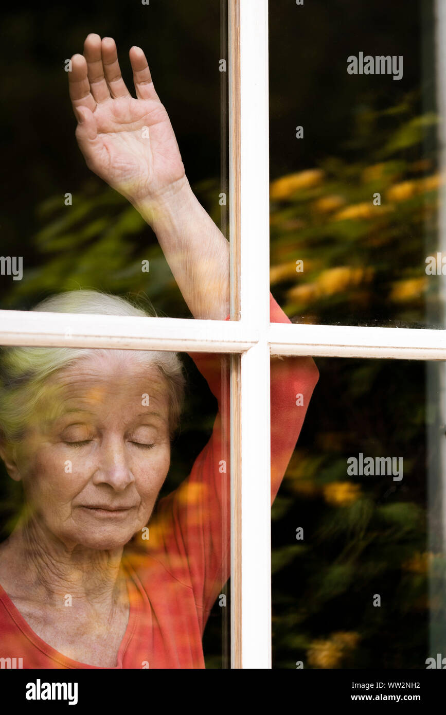 Woman looking through window Stock Photo - Alamy