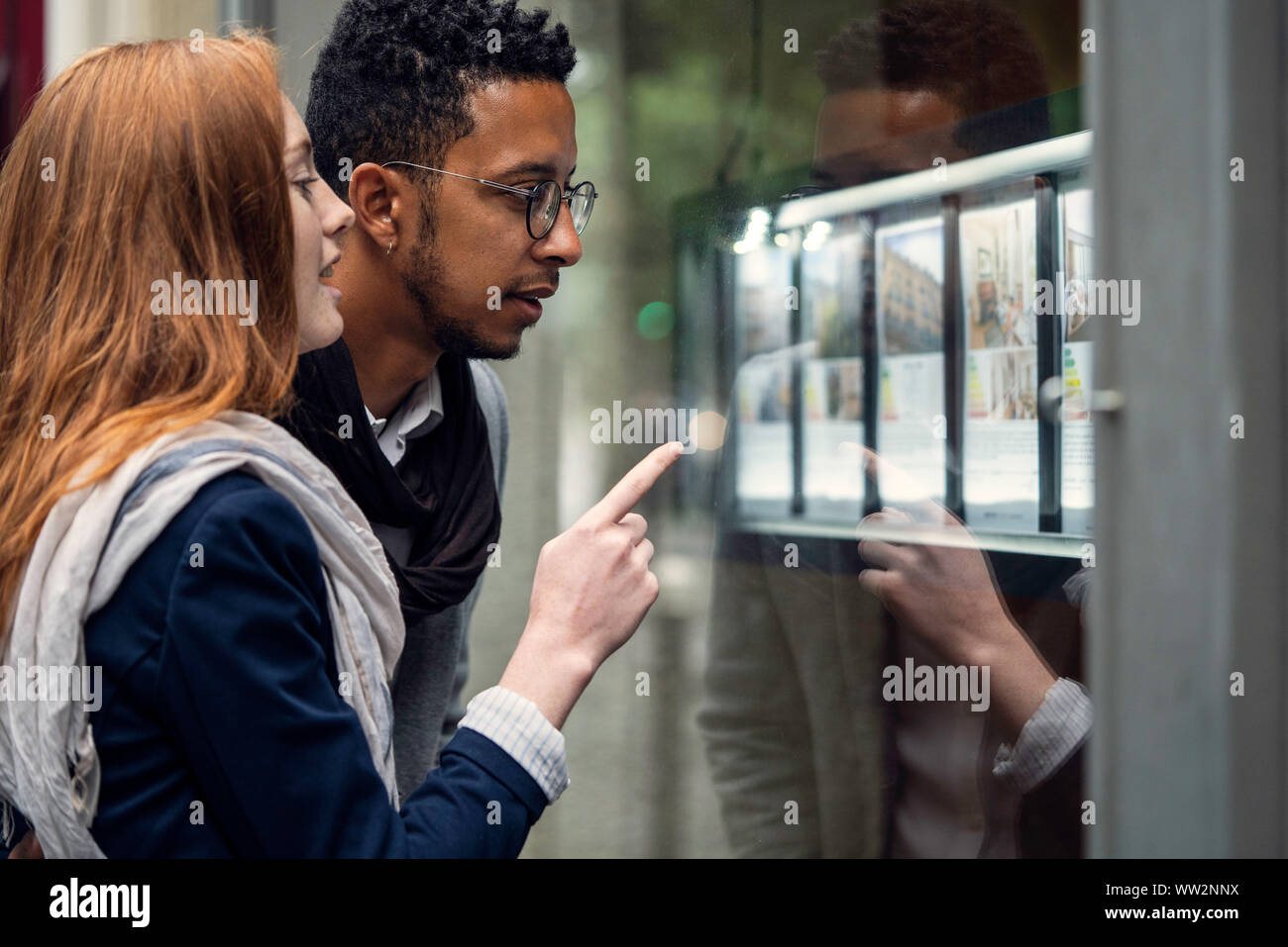 Couple looking at window display Stock Photo - Alamy