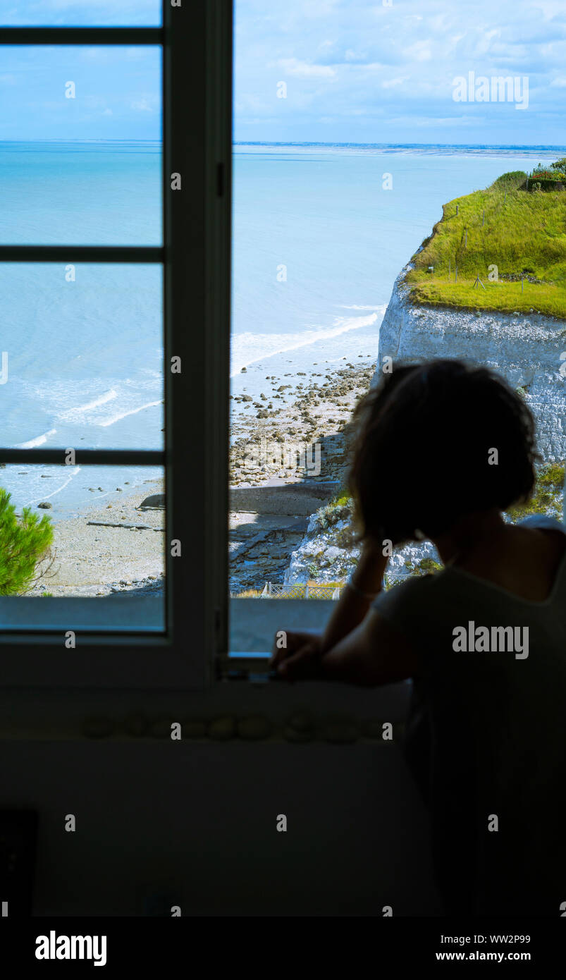 Woman looking through window Stock Photo - Alamy