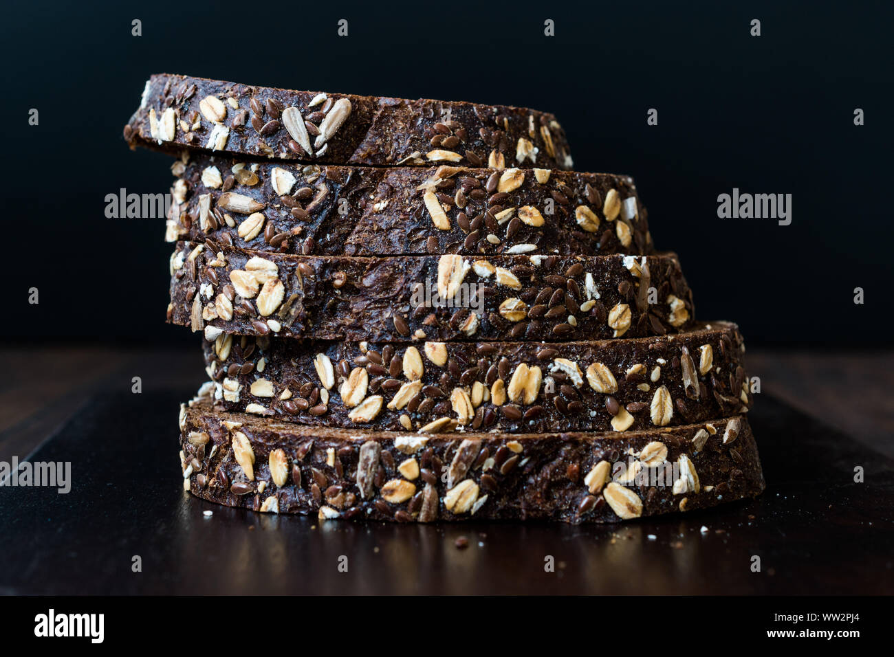 Malt Bread Slices with Oat and Flax Seeds on Dark Wooden Board. Organic ...