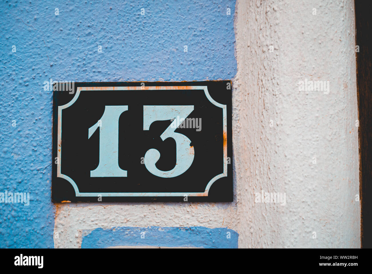 number 13 door sign on blue and white facade Stock Photo - Alamy