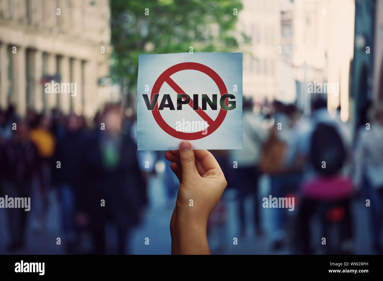 Human hand holding a protest banner stop vaping message over a crowded ...