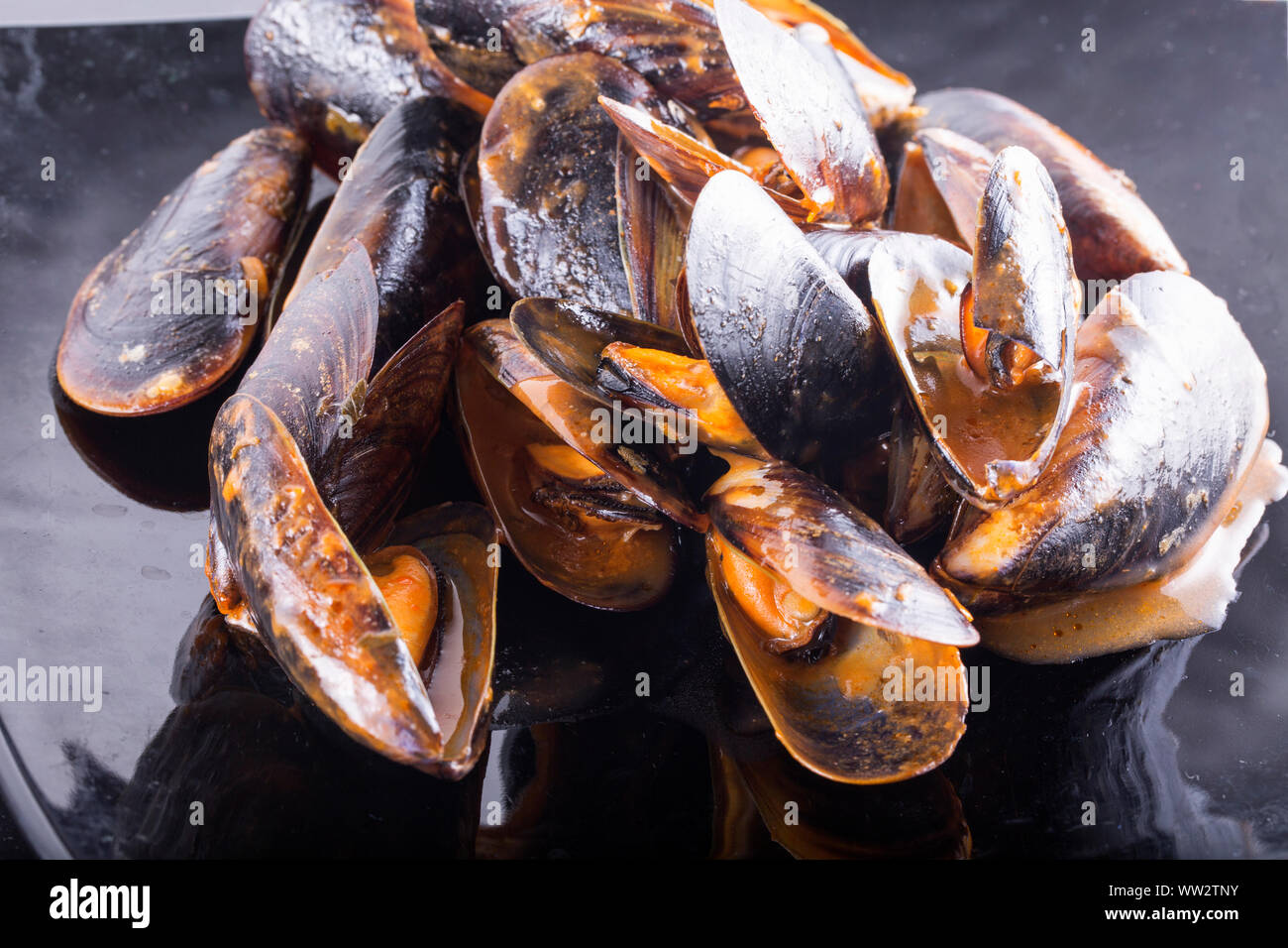 Mussels over black plate, horizontal image Stock Photo - Alamy