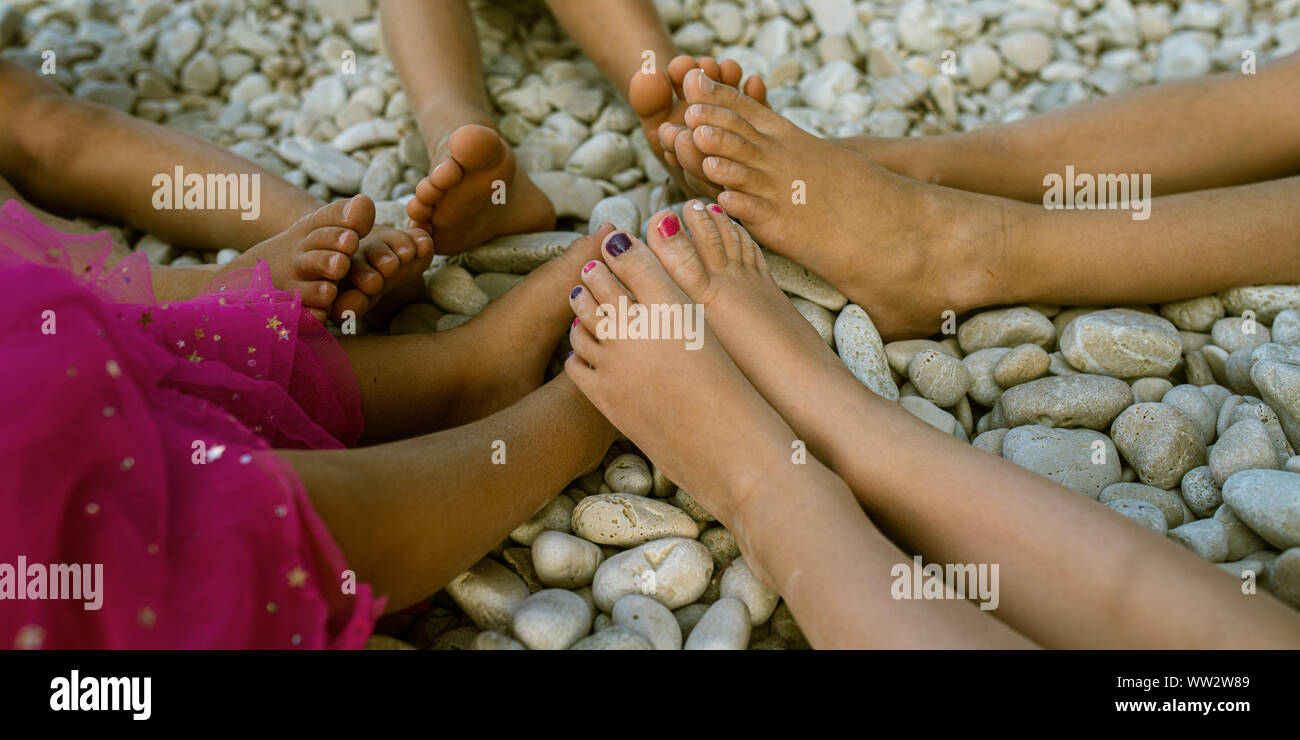 Feet of five little children in a circle on pebble beach Stock Photo ...