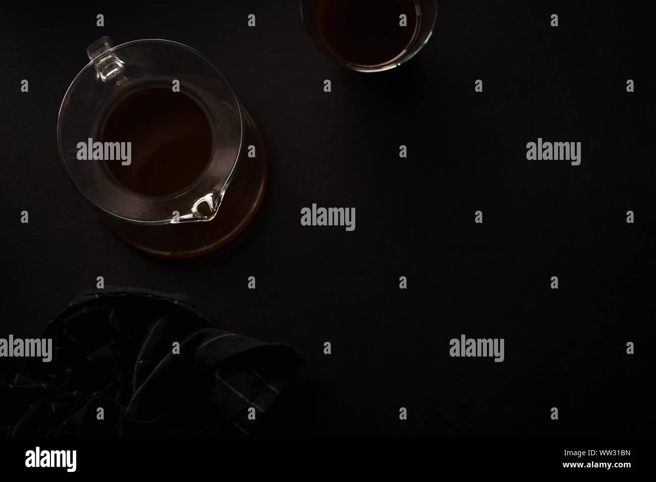 Pour over coffee in picther in two glasses on black background with ...