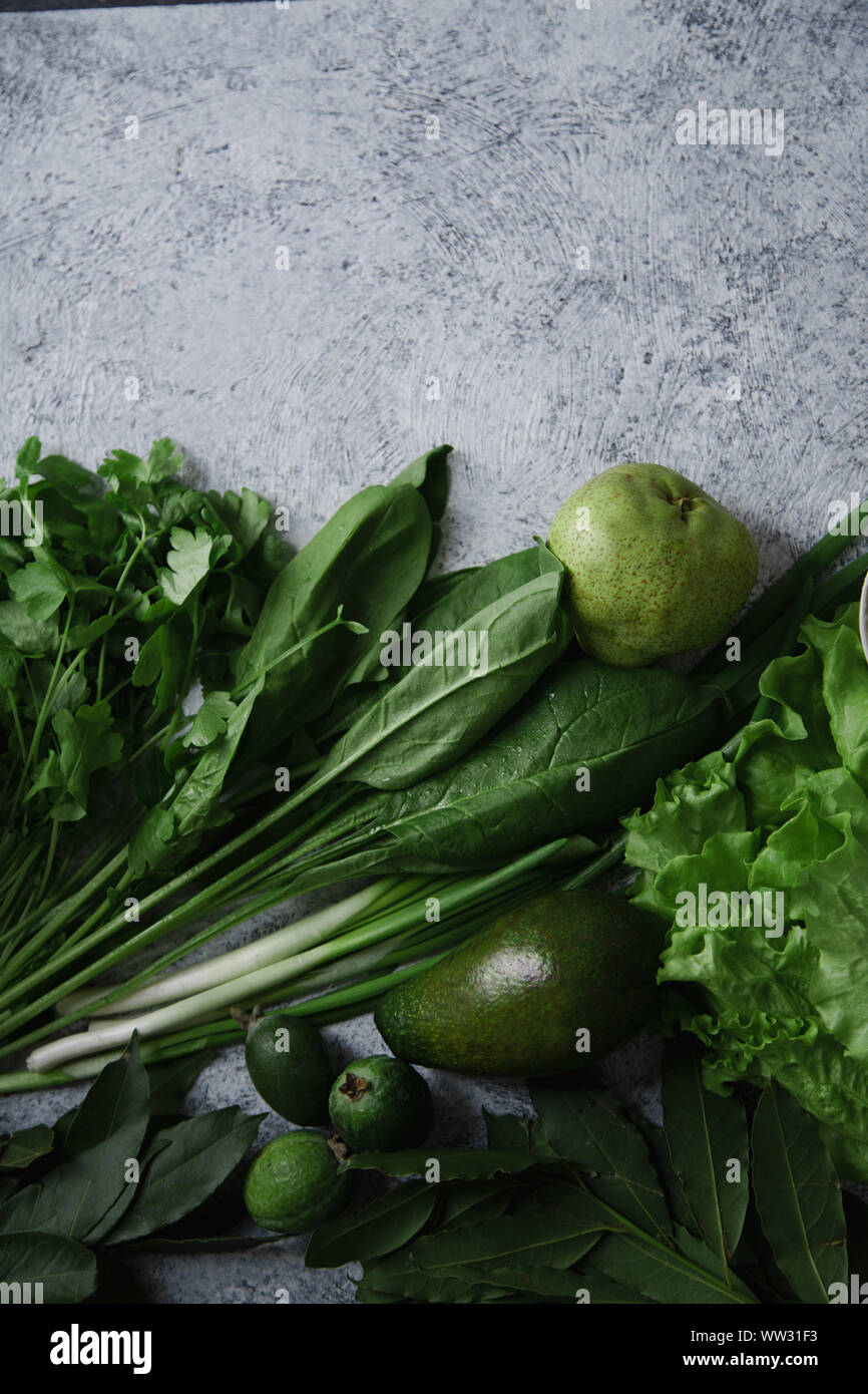 Fresh green food, variety of vegetables, greens and fruits on concrete ...