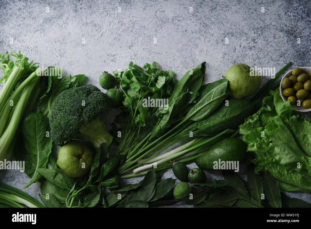 Fresh green food, variety of vegetables, greens and fruits on concrete ...