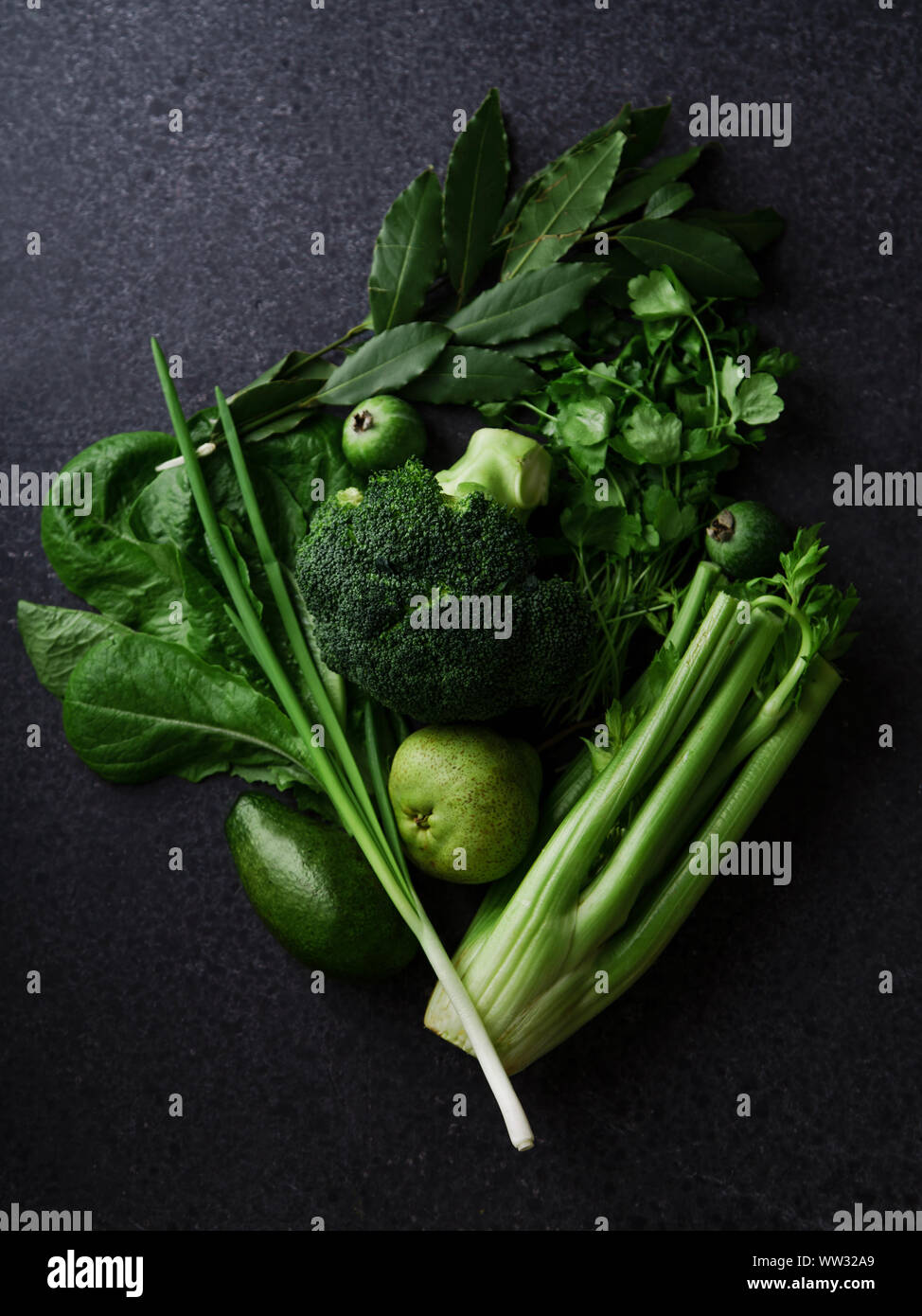 Fresh green food, variety of vegetables, greens and fruits on dark ...