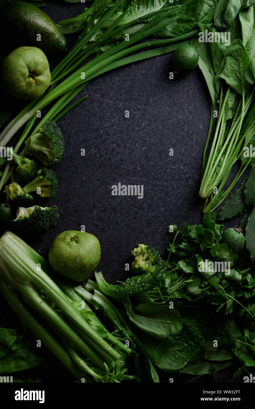 Fresh green food, variety of vegetables, greens and fruits on dark ...