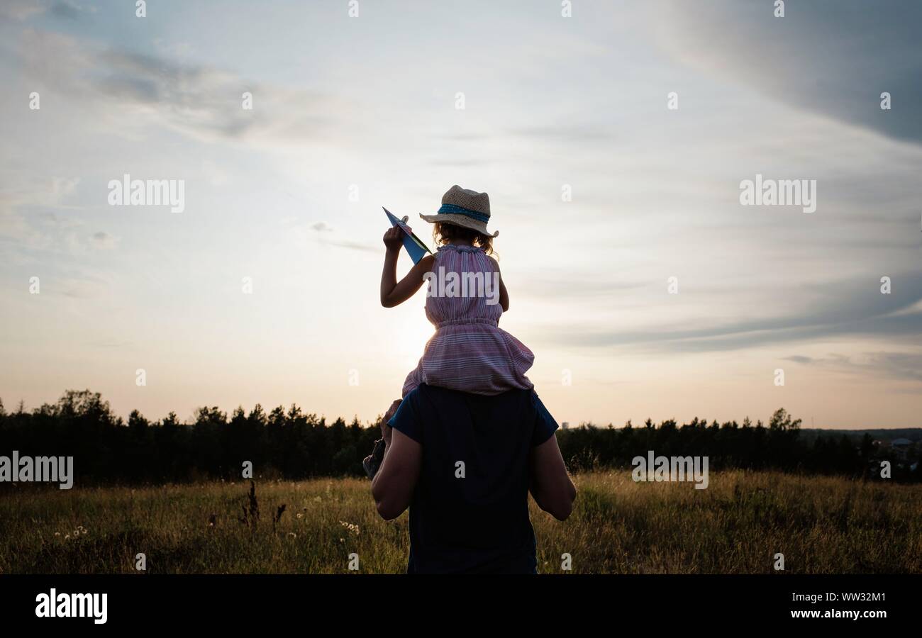 father carrying his daughter on his shoulders walking at sunset Stock Photo - Alamy