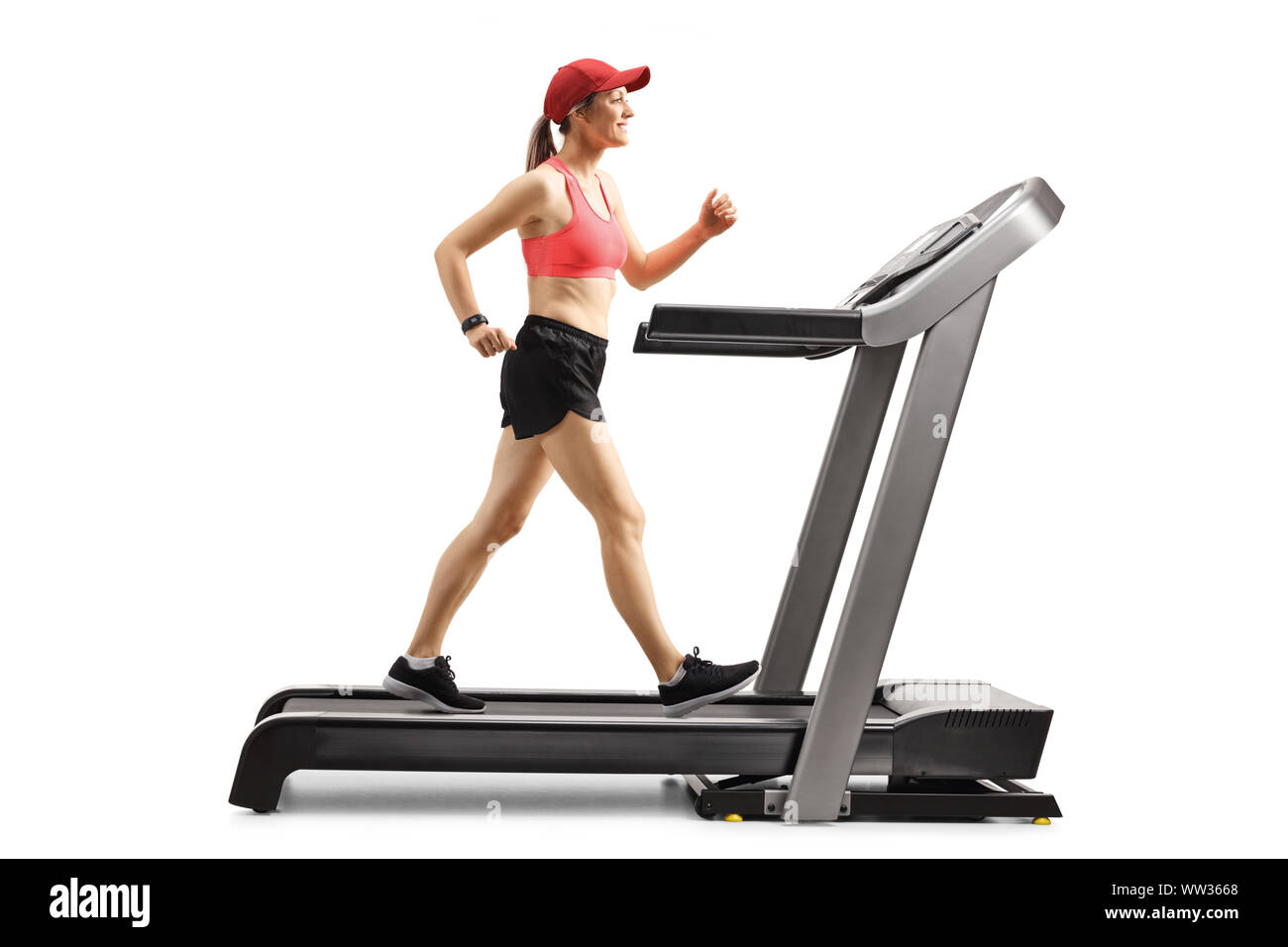 Full length profile shot of a smiling young female exercising on a ...