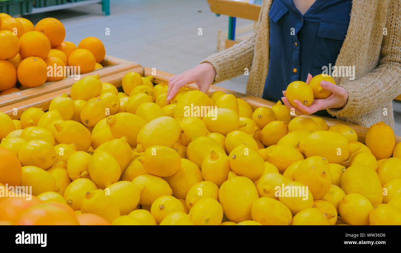 Woman buying fresh yellow lemons at grocery store Stock Photo - Alamy