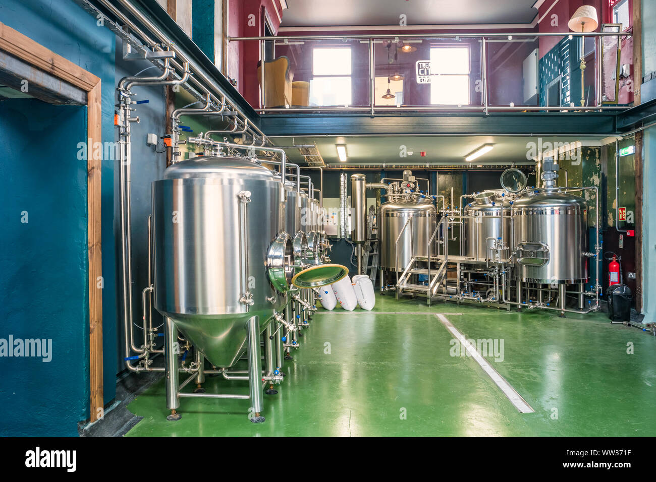 Stainless steel containers inside a brewery as seen through the windows ...