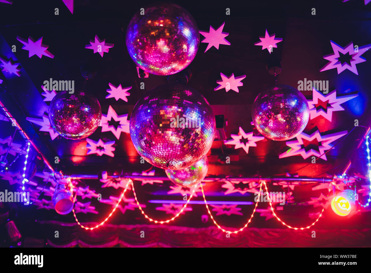 Beautiful shiny balls with colorful lights on ceiling in night club ...