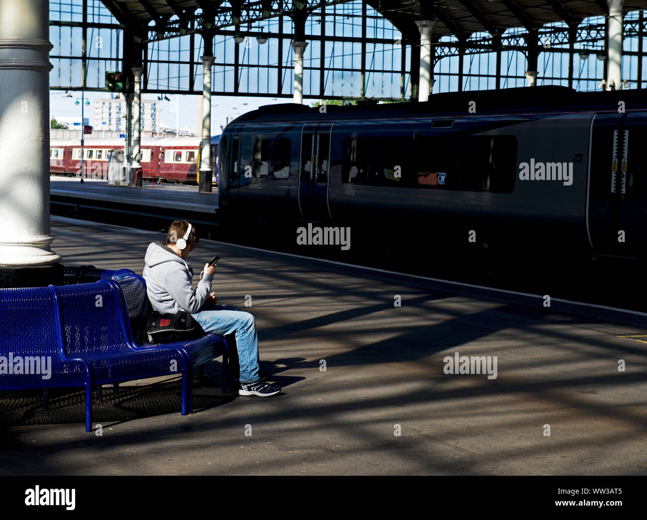 Young man waiting for a train at the railway station, Hull, East ...