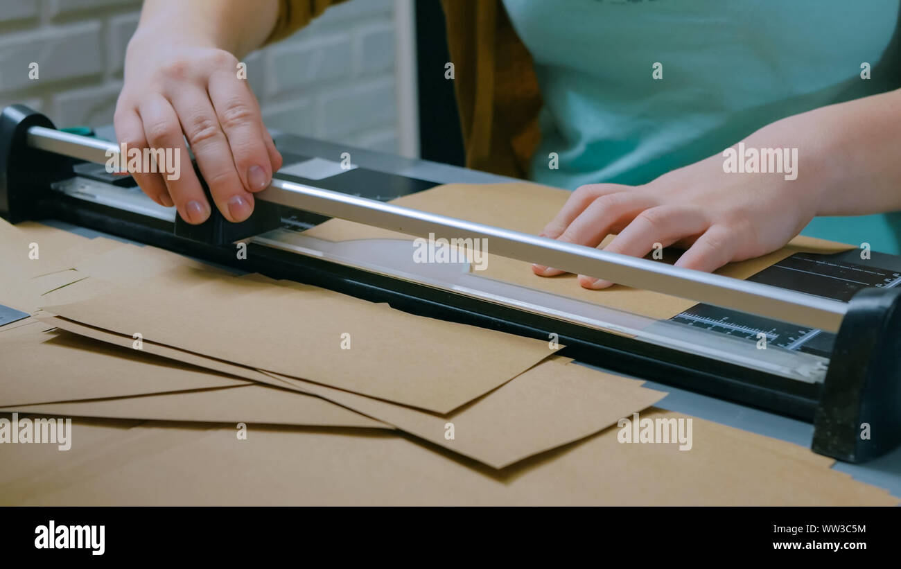 Woman using paper cutter, guillotine, designer working Stock Photo - Alamy