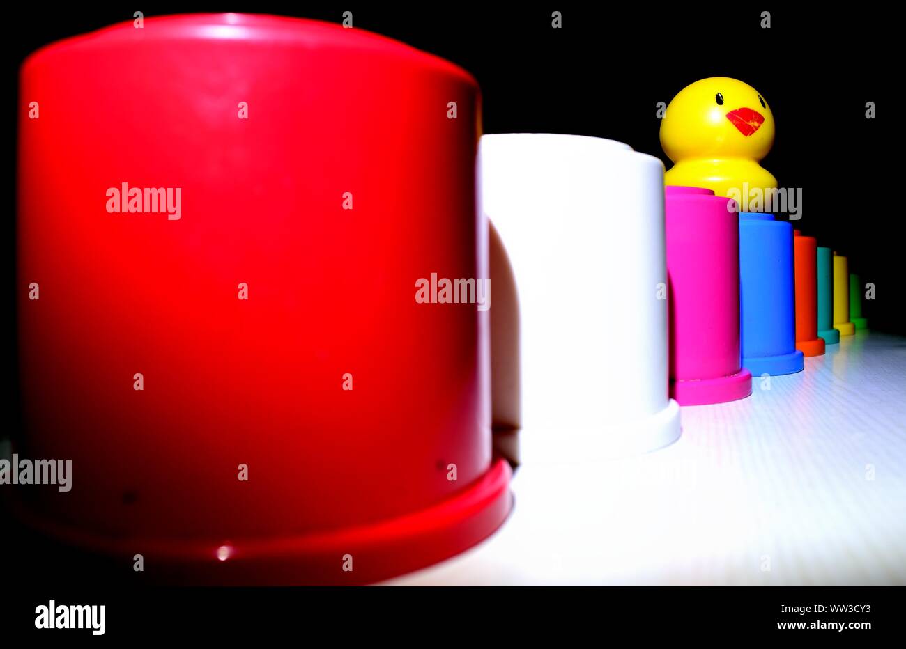 Stacking Drum toy decorated in spot lighted row with black background ...