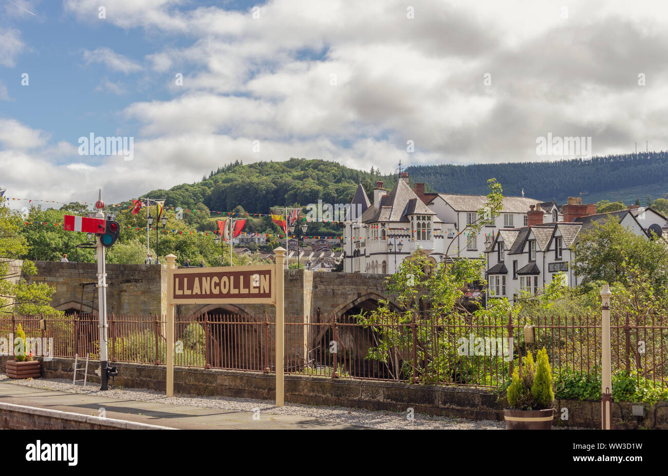 Llangollen railway station platform with location sign and signal. A ...
