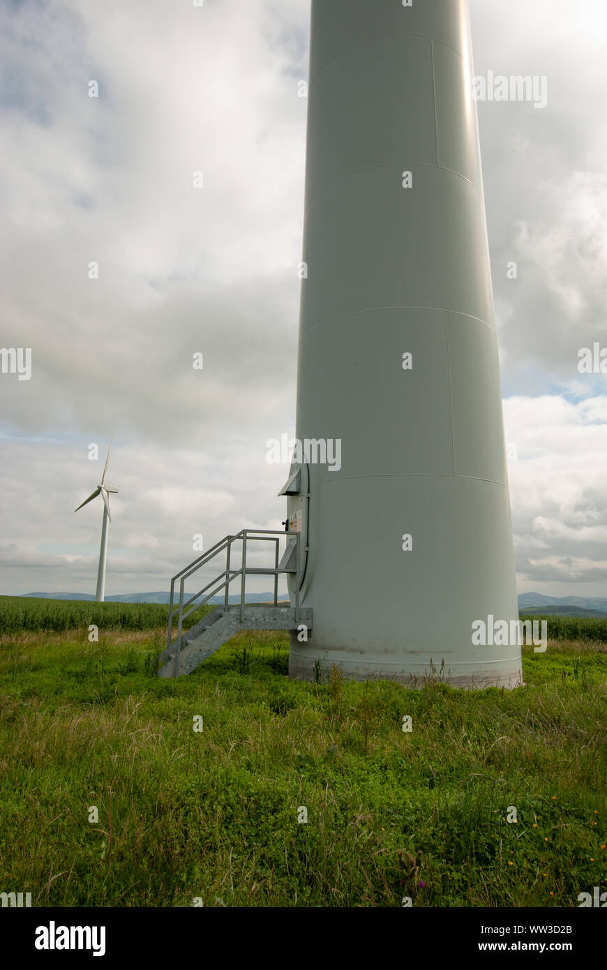 Wind turbine base with access steps with wind turbine in the distance ...