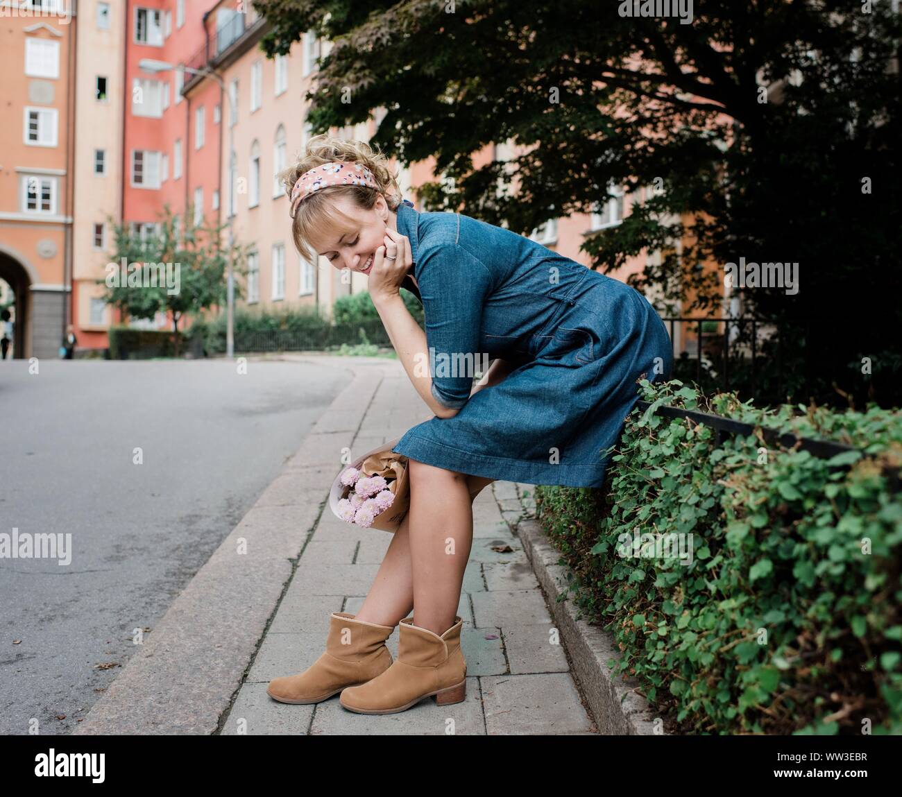 portrait of a female sitting outside a house with flowers waiting Stock ...