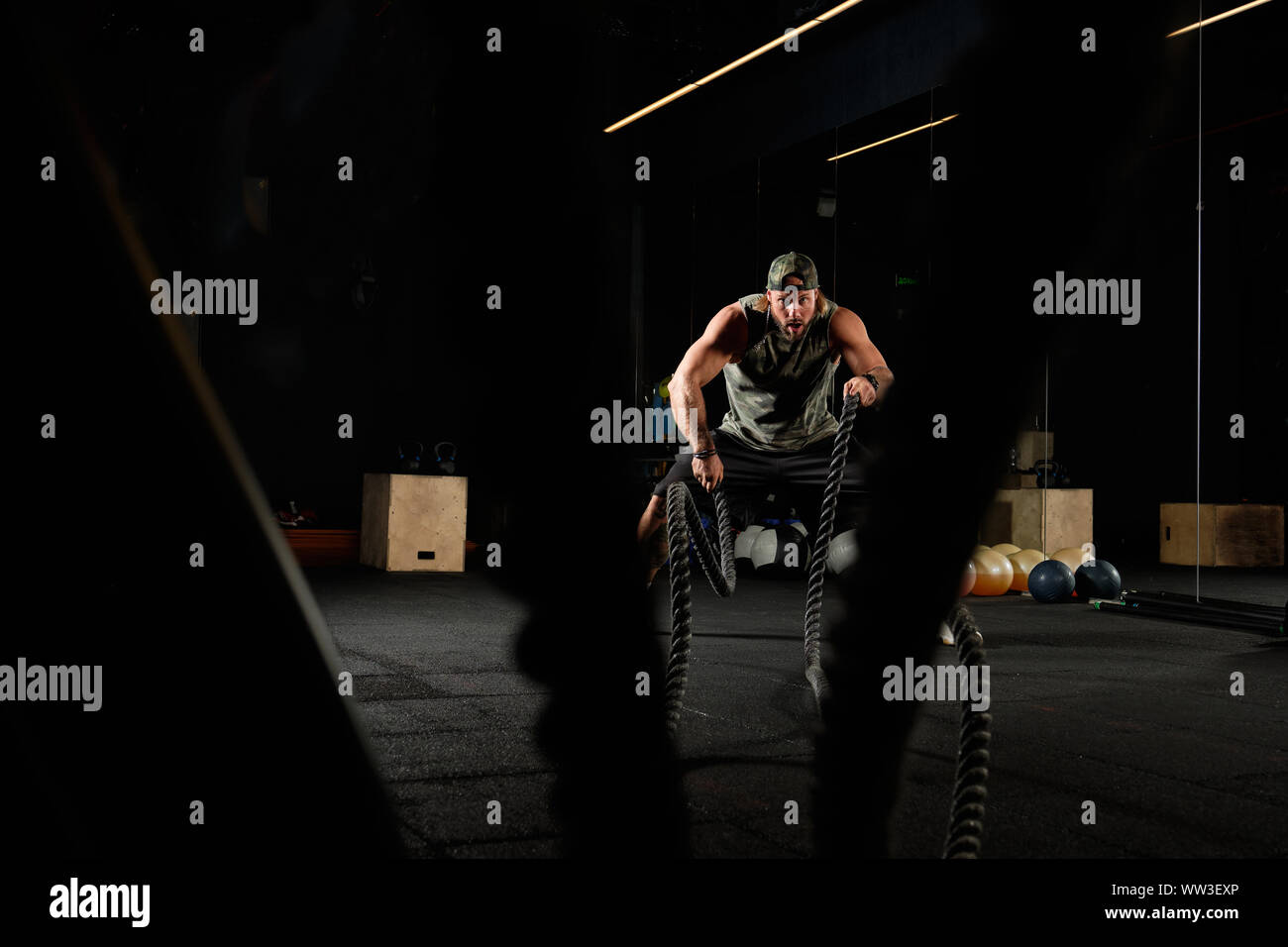Inflated man performs an exercise with ropes, view from the side of the ...
