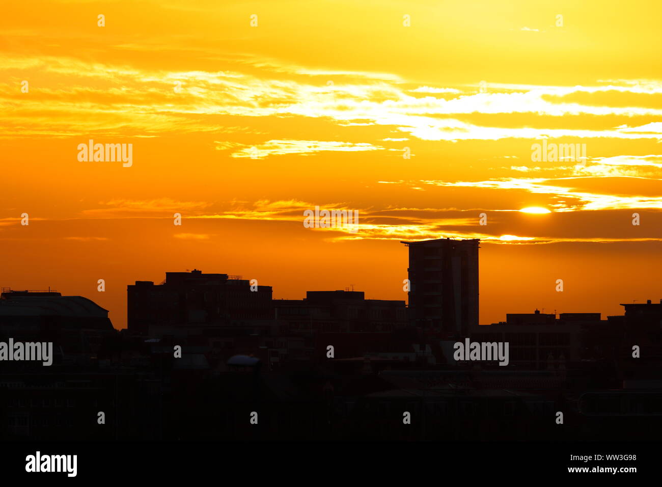 The sun rising behind a building in Leeds City Centre Stock Photo - Alamy
