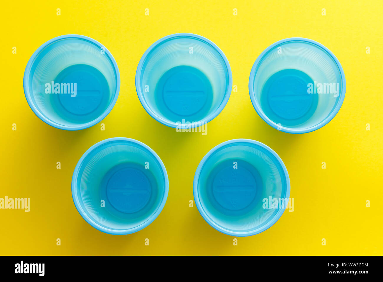 Five empty blue plastic disposable cups over a yellow background Stock ...