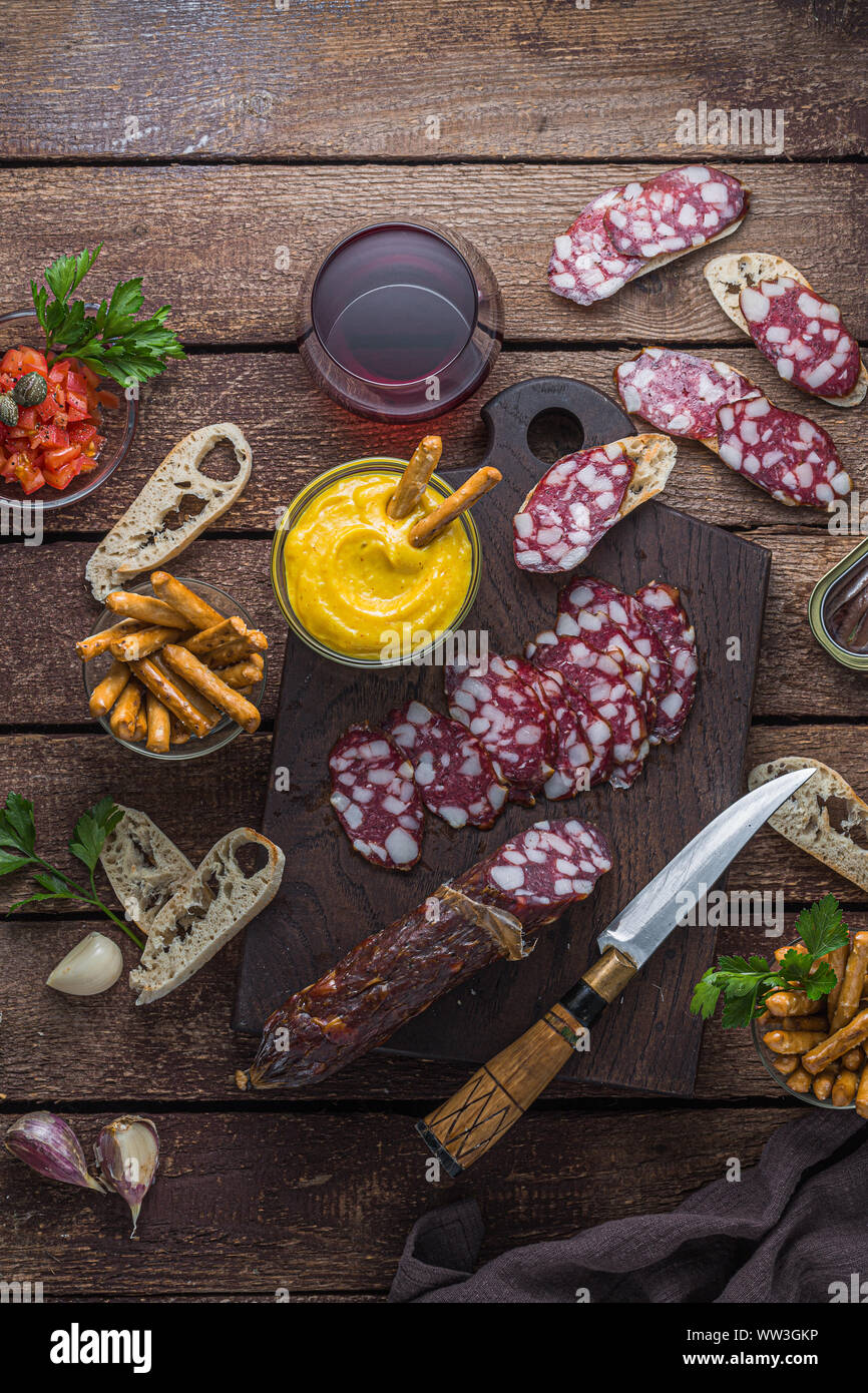 Cured sausage and crusty bread with red wine, top view Stock Photo - Alamy