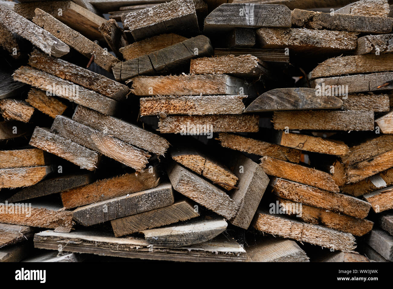 Folded old wooden brown and gray planks in a sawmill. Piled alder ...