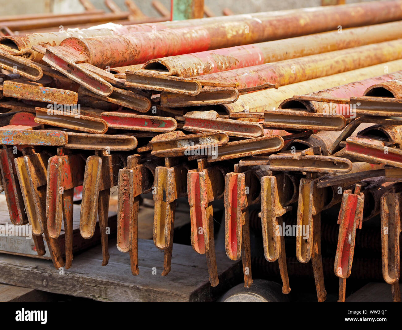 stack of rusty scaffolding posts with angular feet loaded on a flatback ...