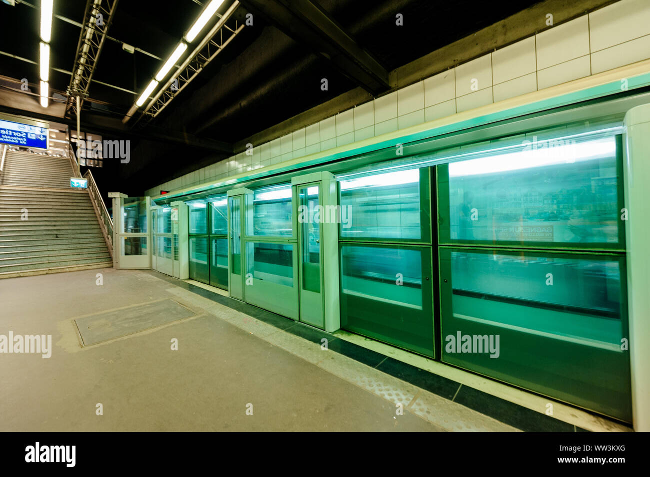 Fast Parisian Metro train passing behind security barrier at the ...