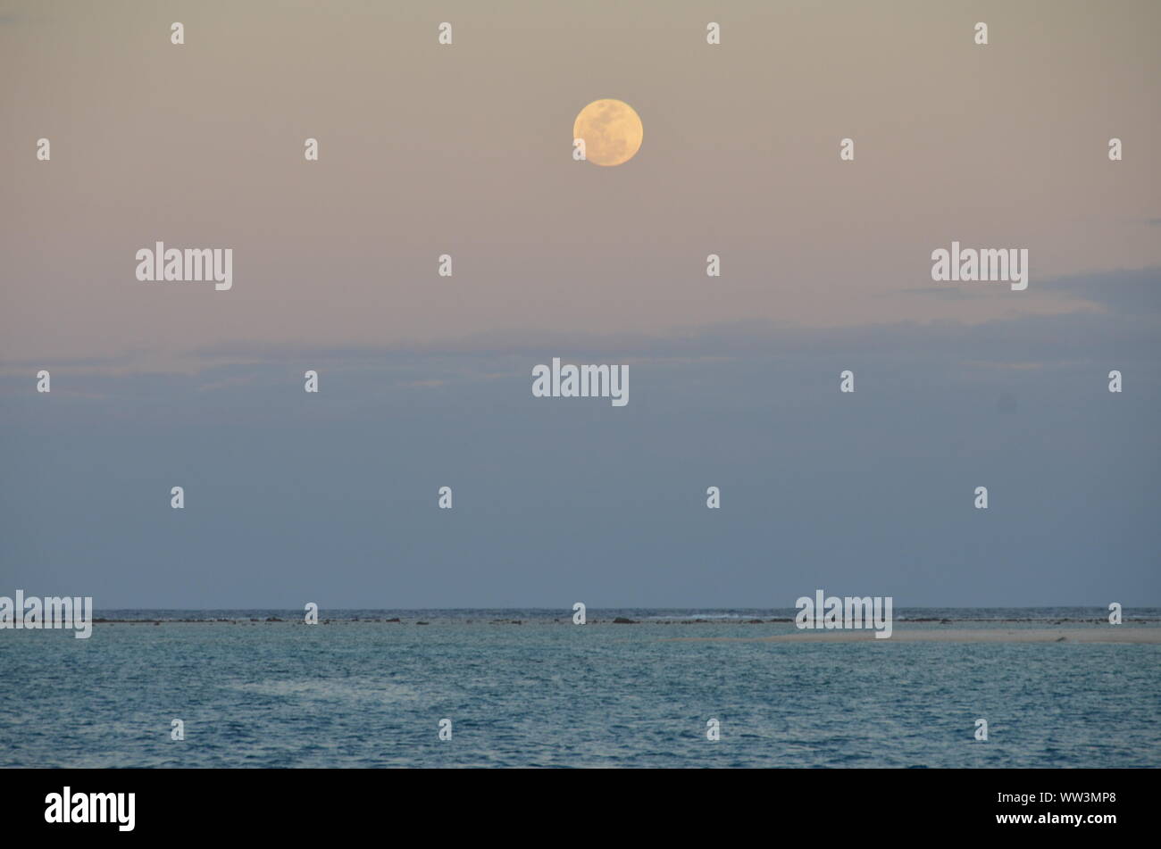 moon in the shadows over the South Pacific Ocean in Tuamotu Archipelago ...