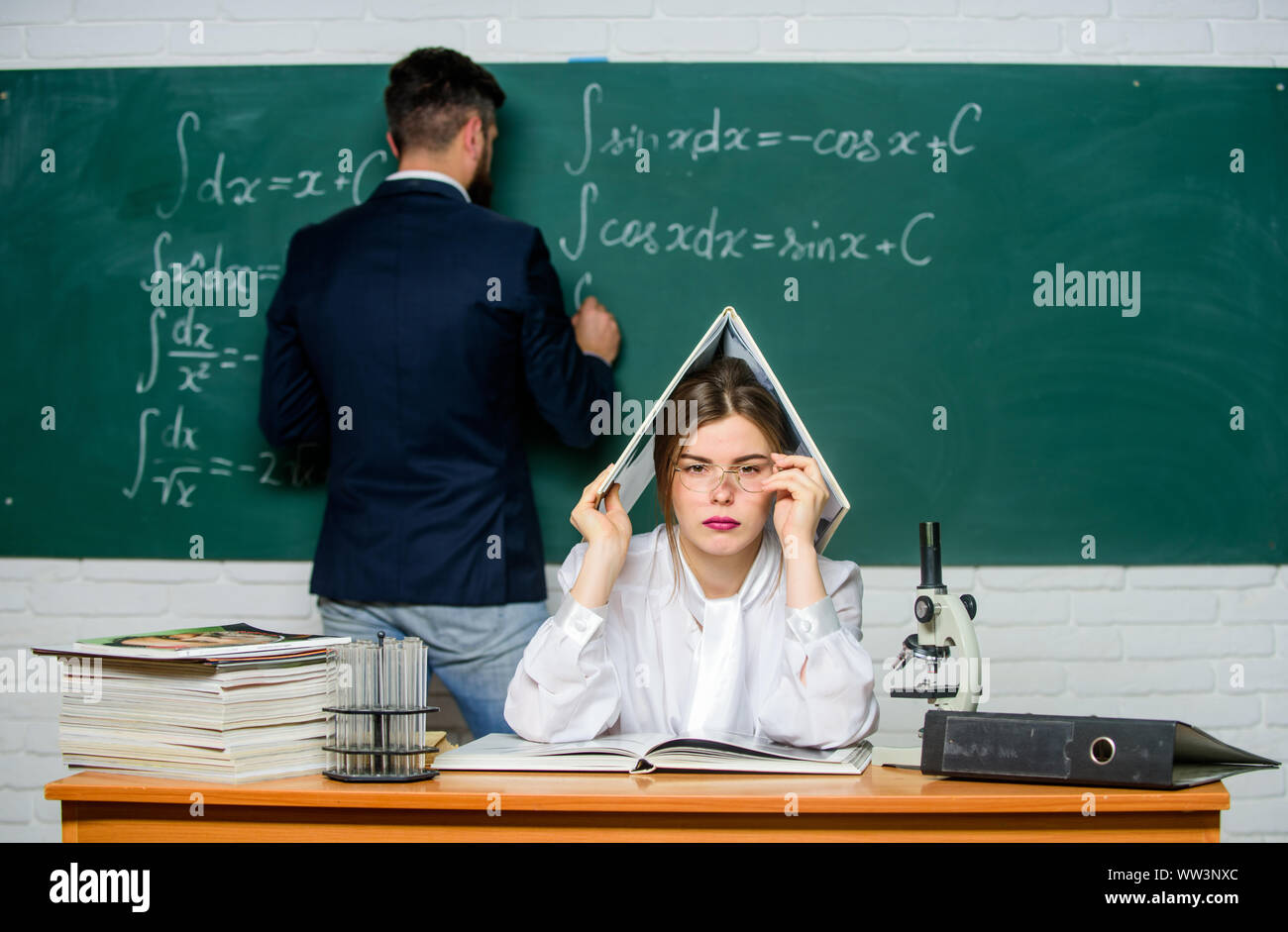 Solving task. Man writing on chalkboard math formulas. Teaching in ...