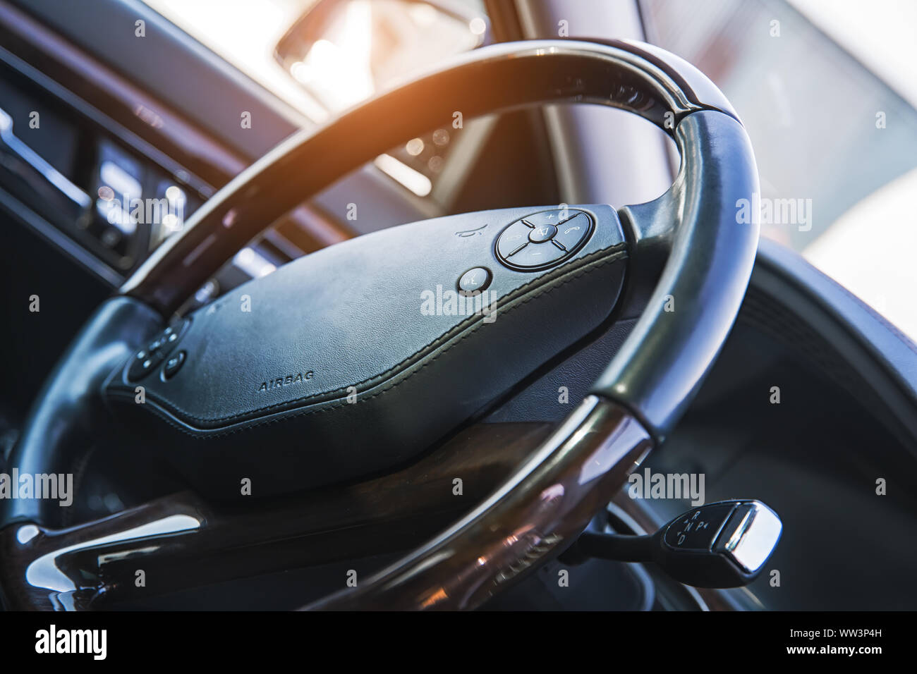 car steering wheel with shallow depth of field with background flare ...