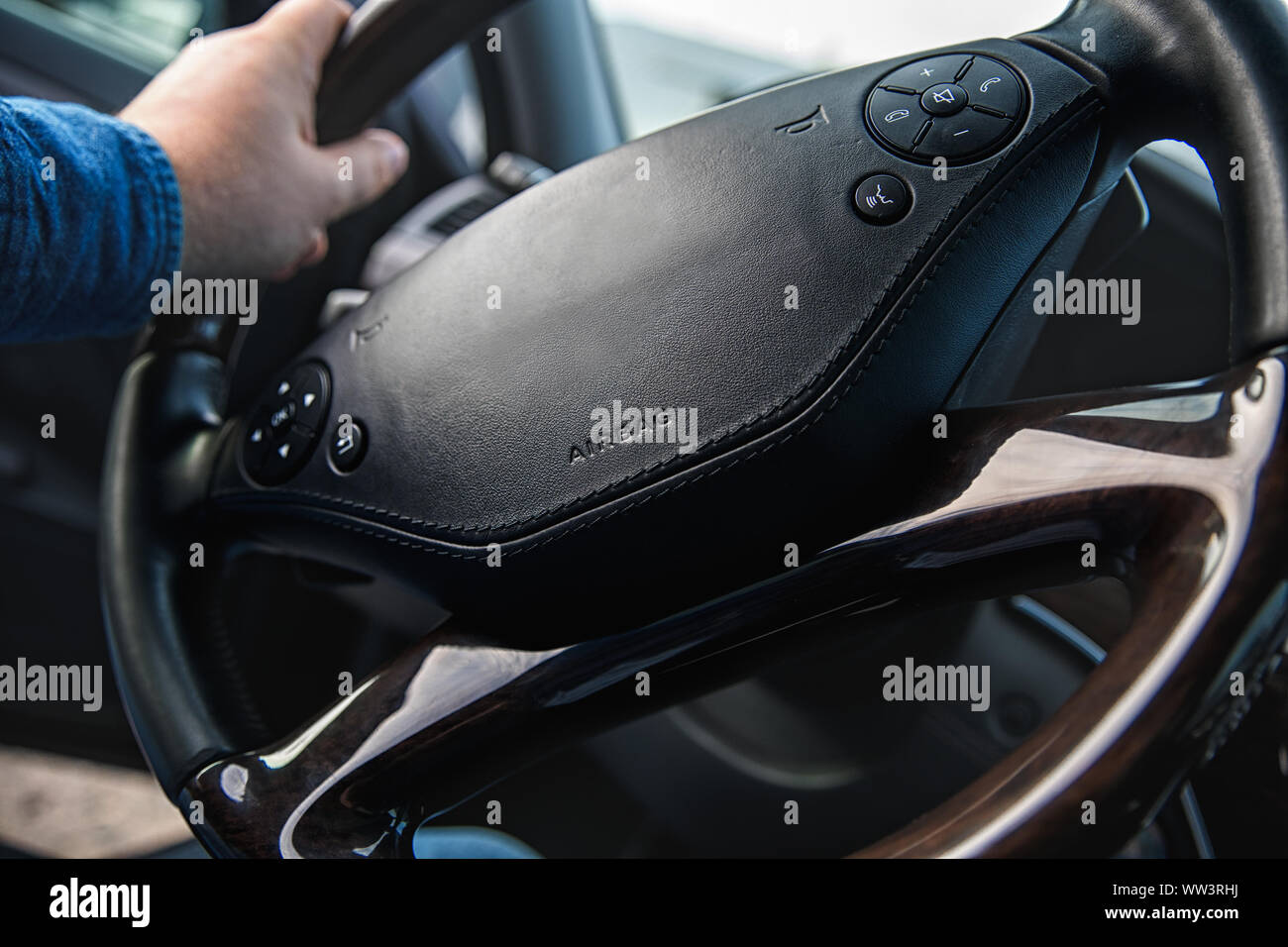 car steering wheel with shallow depth of field and hand in the ...