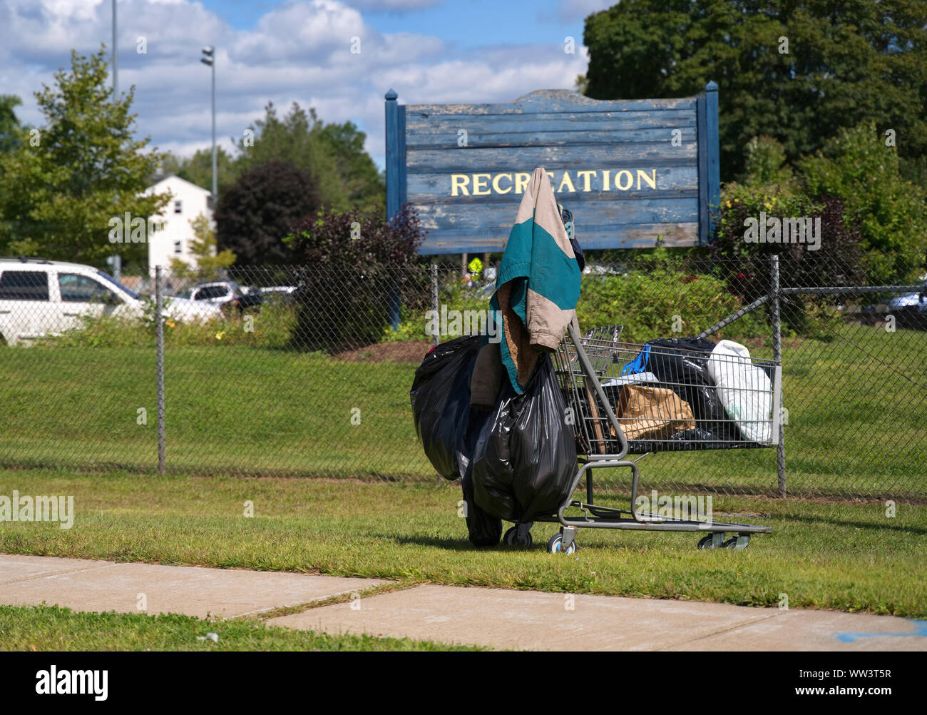 A homeless mans shopping cart full with recyclable soda cans, clothing ...